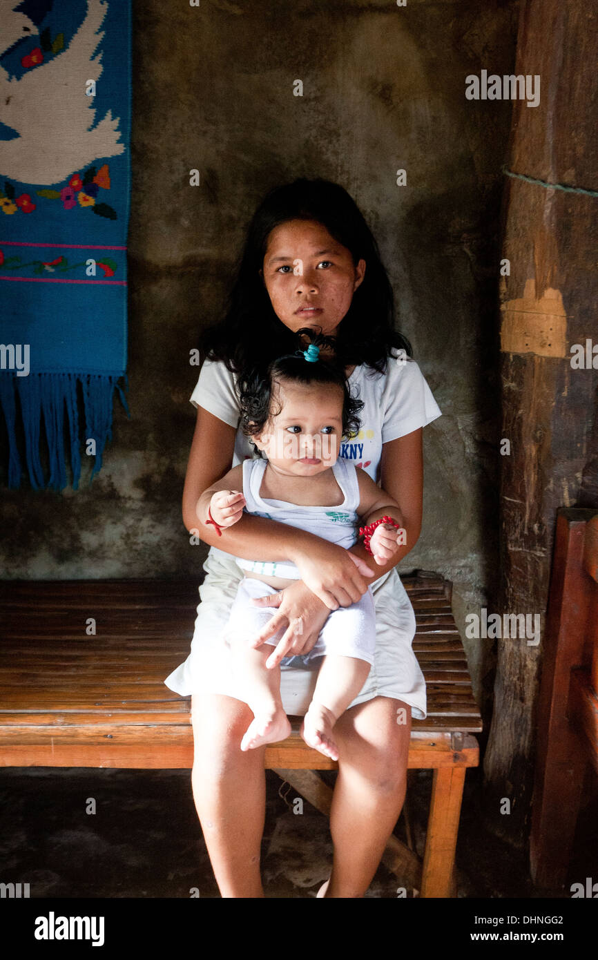 A young girl takes care of her young sister in their village on Samar ...