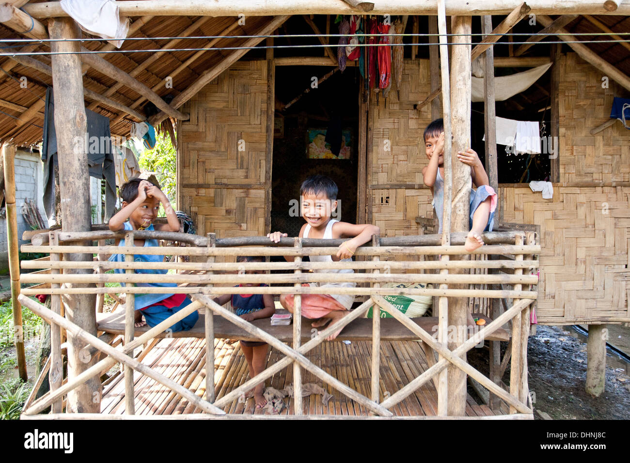A trio of young boys laugh together on the deck of their home on Samar ...