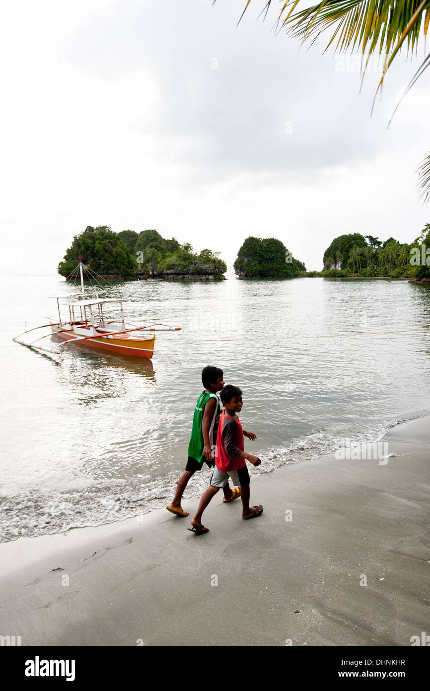 Two young boys walk along the shore line on the island of Samar Stock ...