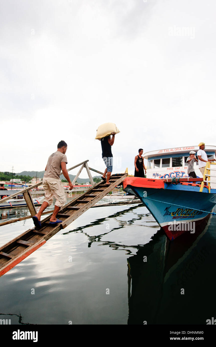 Men load their boats at a wharf at Tacloban City, Leyte Stock Photo - Alamy