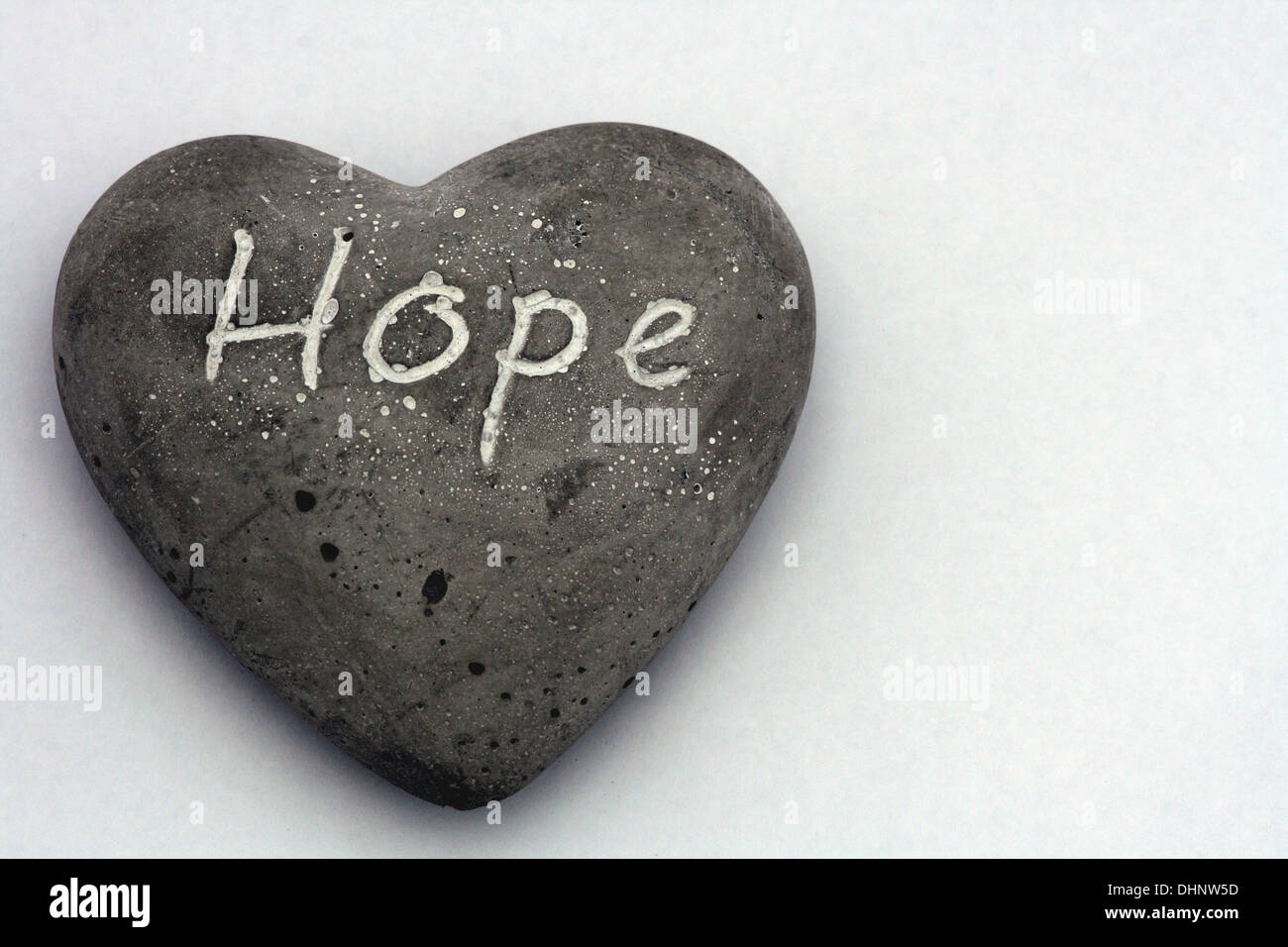 The word "hope" is painted onto a small heart-shaped stone Stock Photo ...