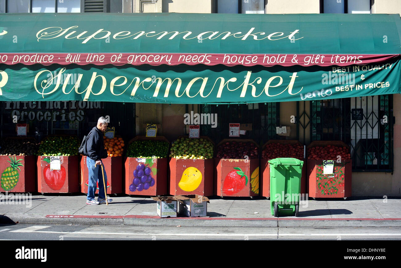 old man walk past grocery store in the mission district of San ...