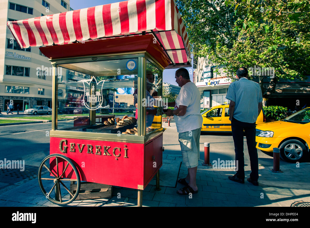 Tourist purchasing pretzel from a street food vendor in Izmir Turkey ...