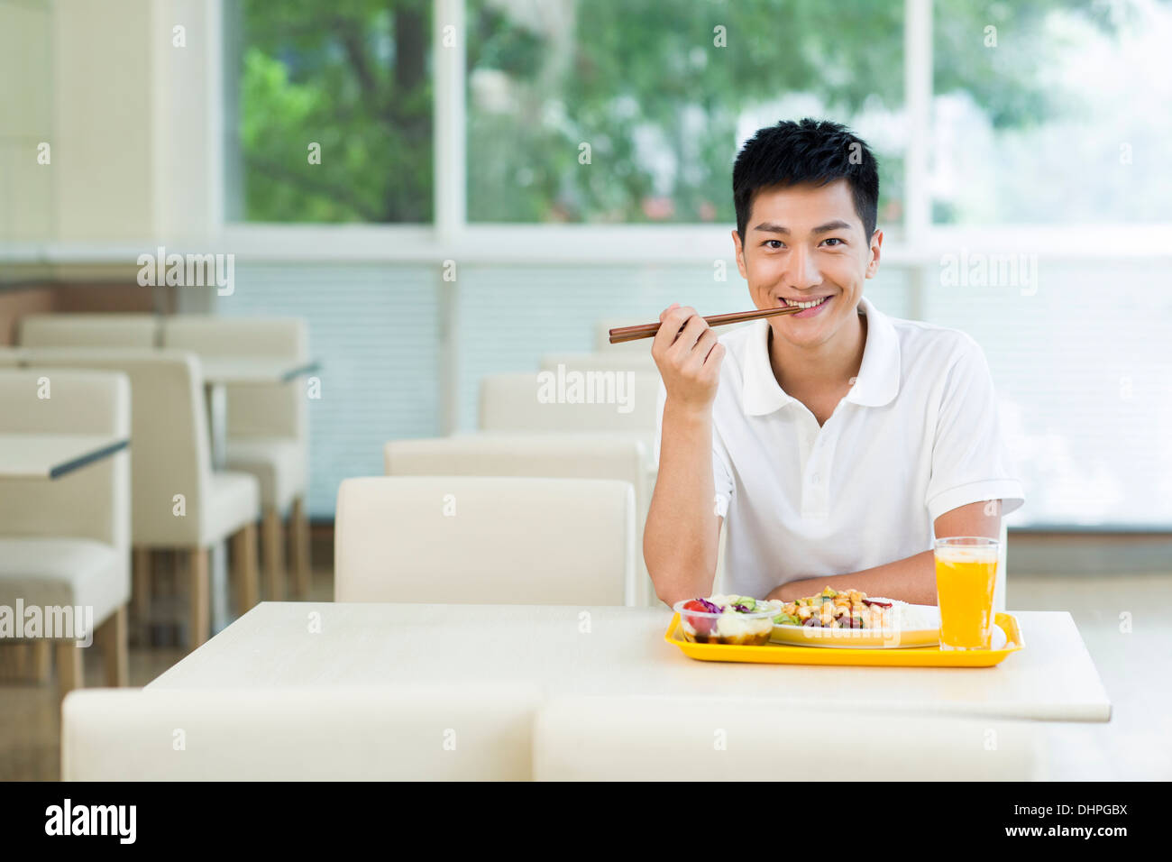 Happy young man dining in restaurant Stock Photo - Alamy