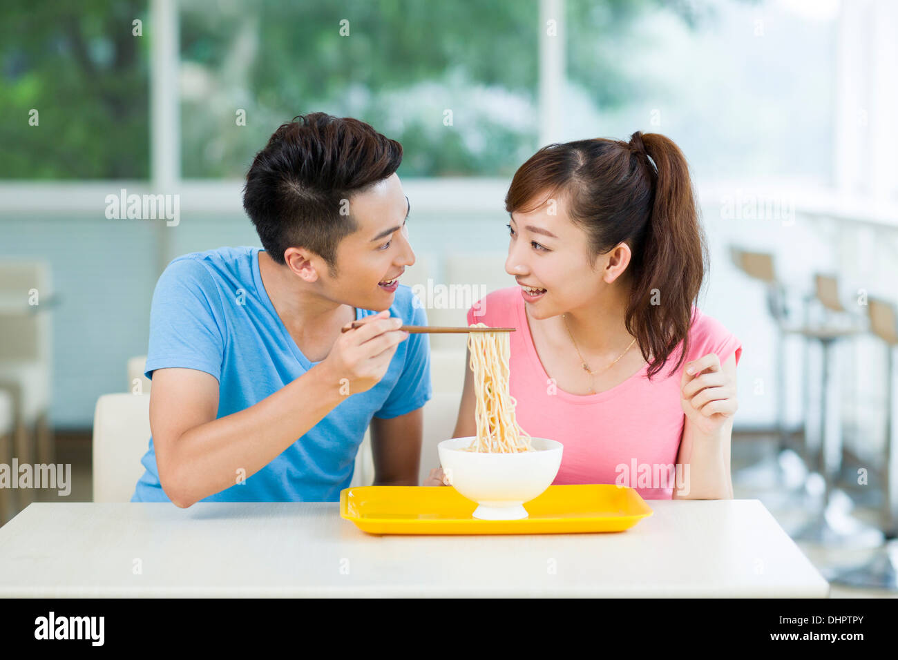 Young couple having noodles in restaurant Stock Photo - Alamy