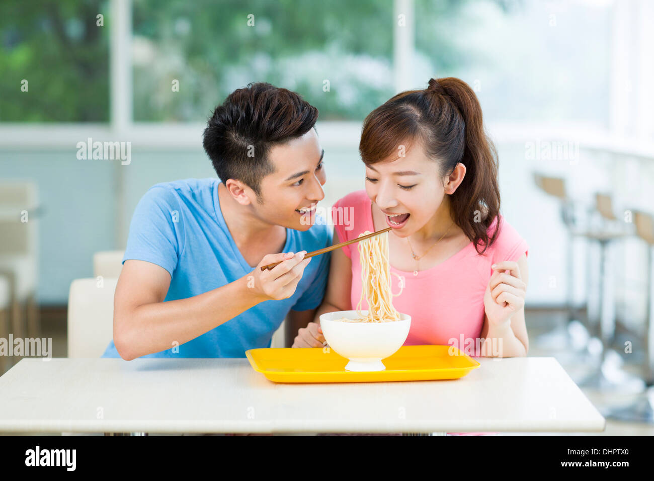 Young couple having noodles in restaurant Stock Photo - Alamy