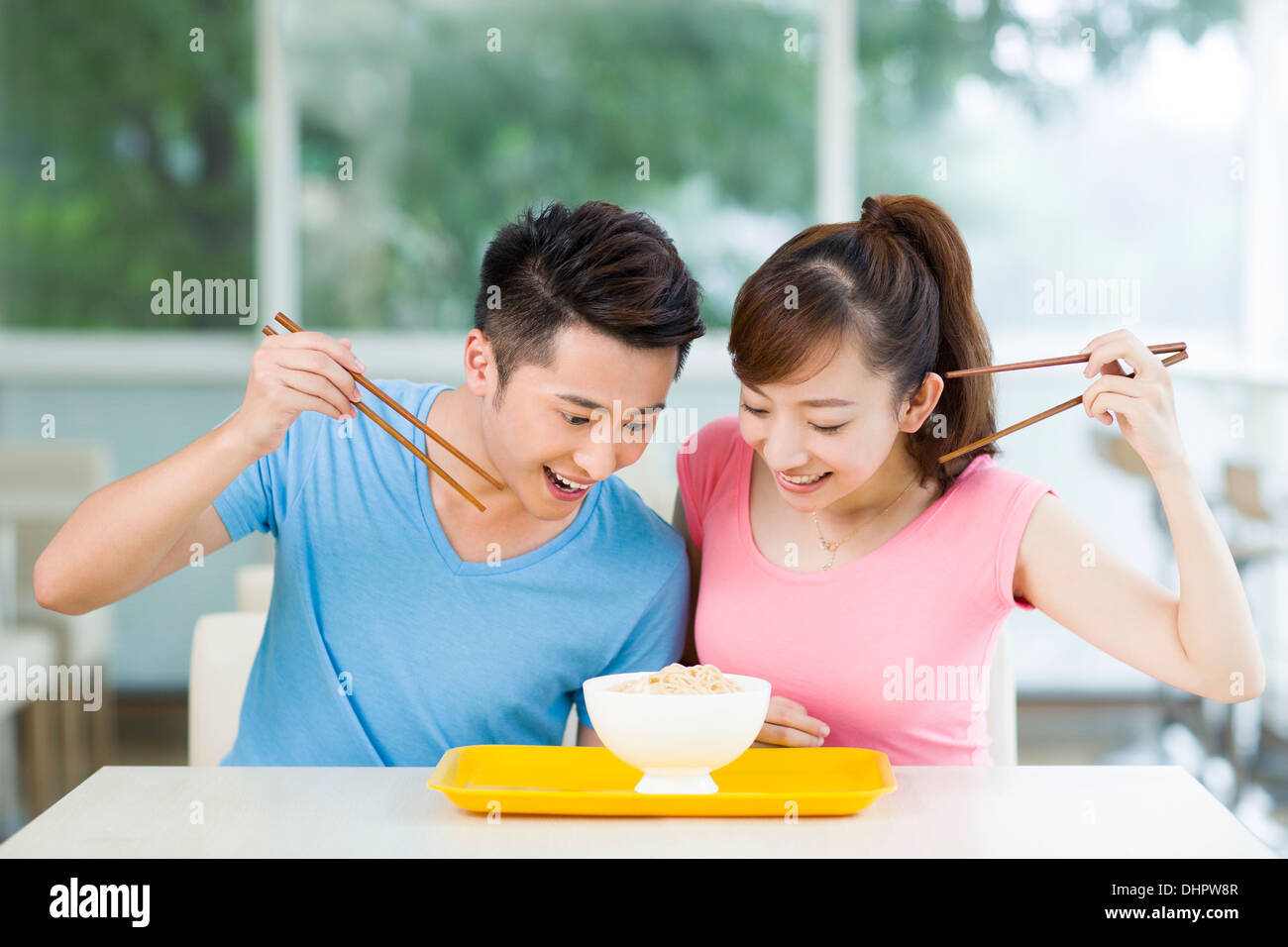 Young couple having noodles in restaurant Stock Photo - Alamy