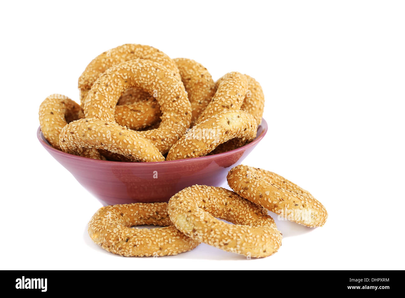 Round rusks with sesame seeds in pink bowl isolated on white background ...
