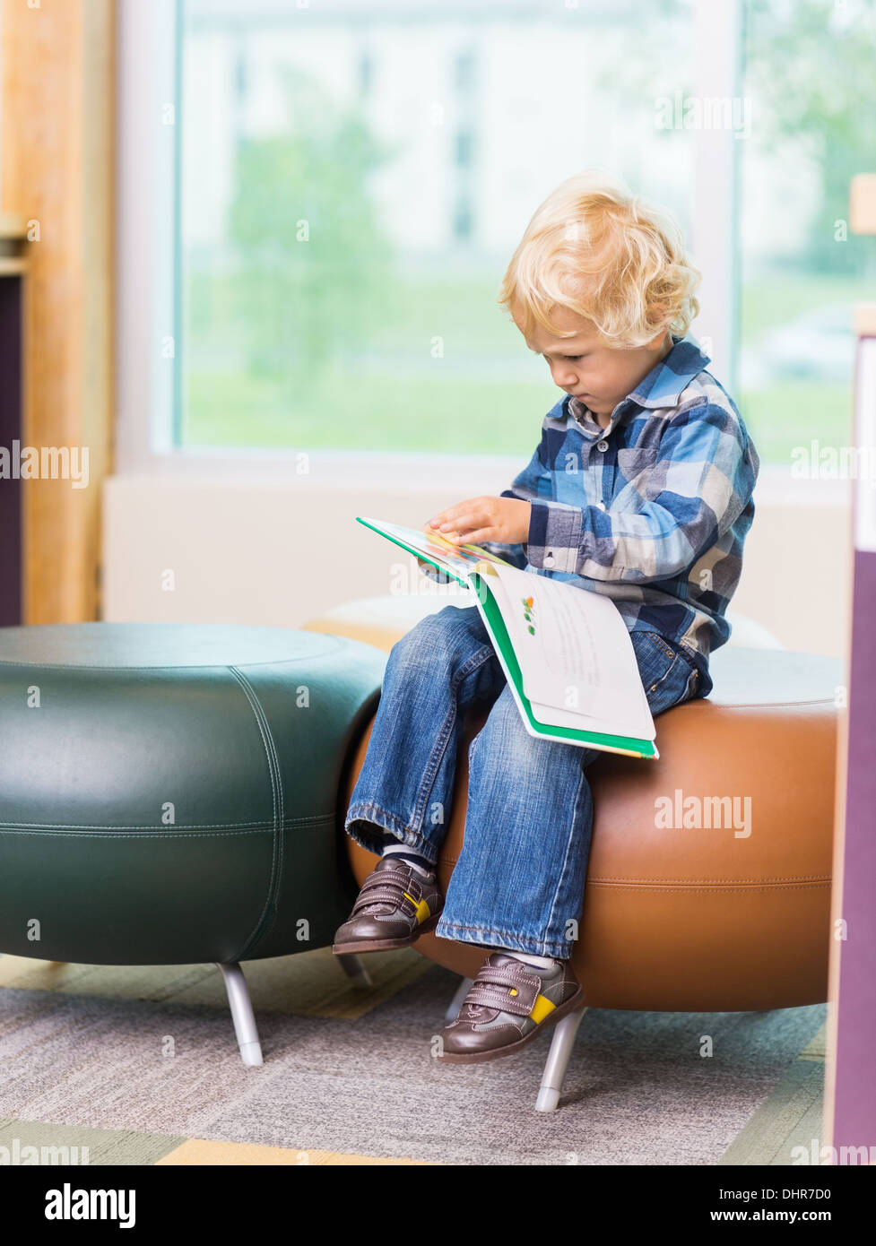 Cute Boy Reading Book In School Library Stock Photo - Alamy