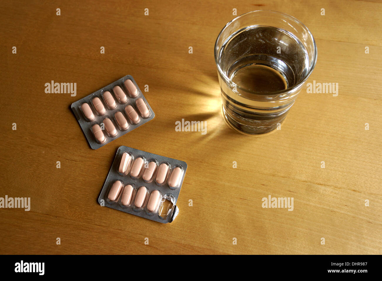 Medication tablets and glass of water Stock Photo - Alamy