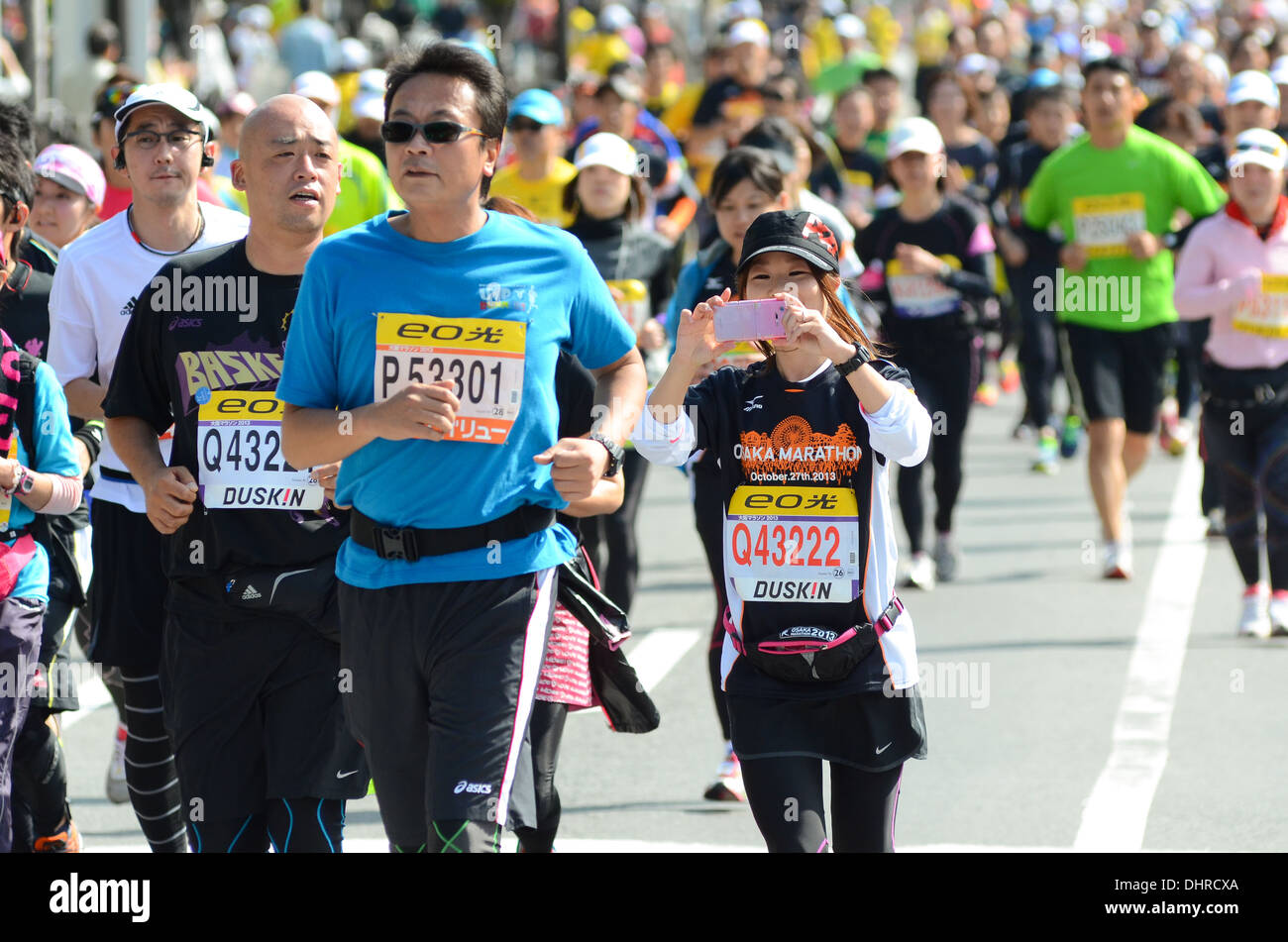 A runner taking a photograph during a marathon in Osaka, Japan Stock ...