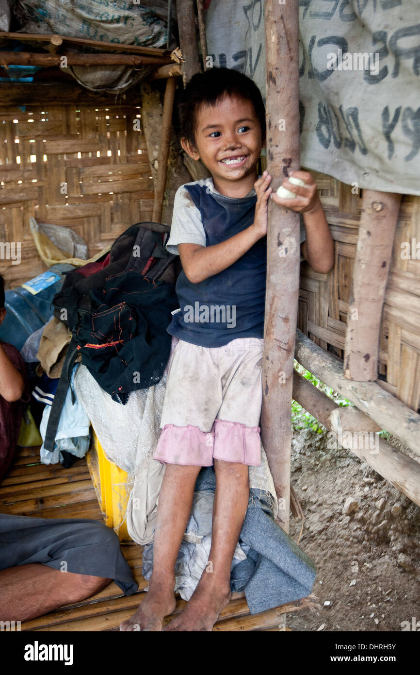 A young child giggles as she stands in her home in a village on the ...