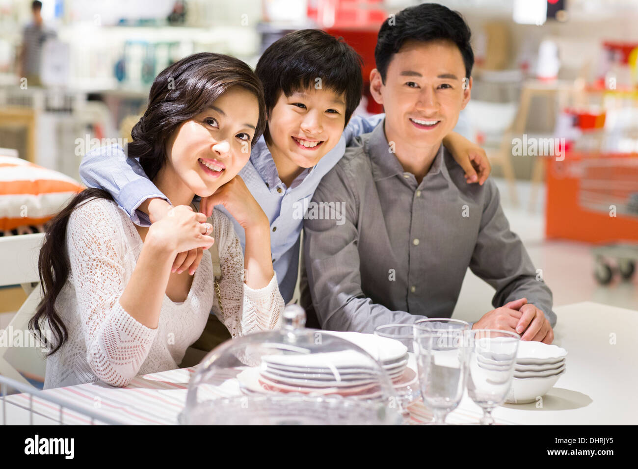 Cheerful family sitting side by side and smiling Stock Photo - Alamy