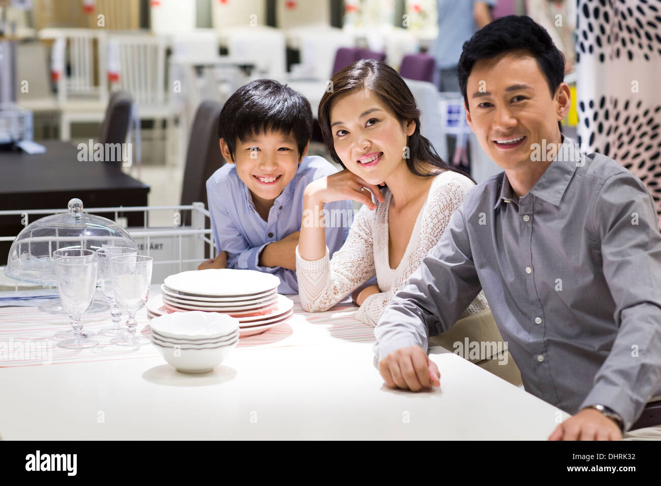 Cheerful family sitting side by side and smiling Stock Photo - Alamy