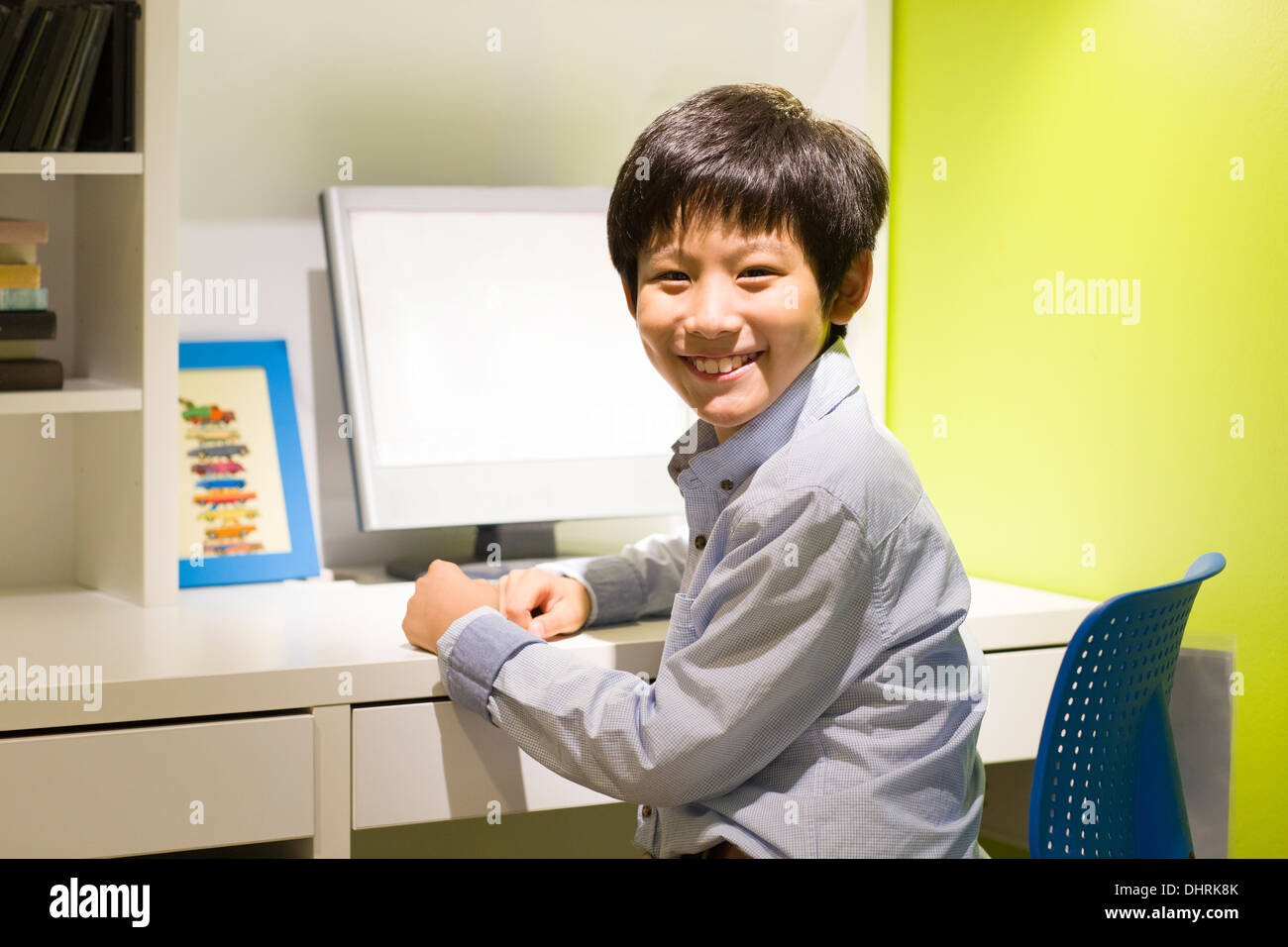 Happy boy sitting at his desk Stock Photo - Alamy