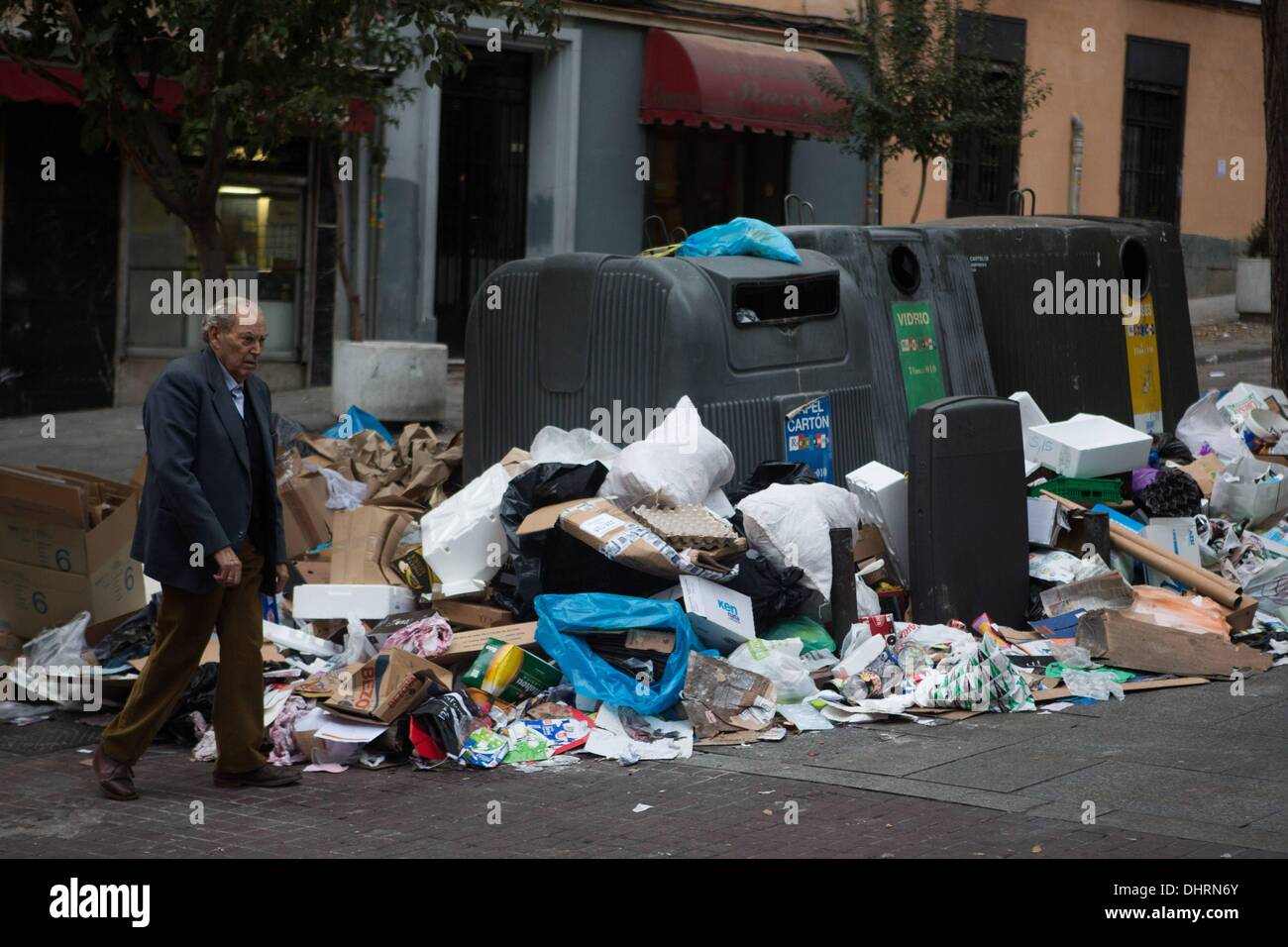 Madrid, Spain. 8th Nov, 2013. A man walk past piles of rubbish dumped ...