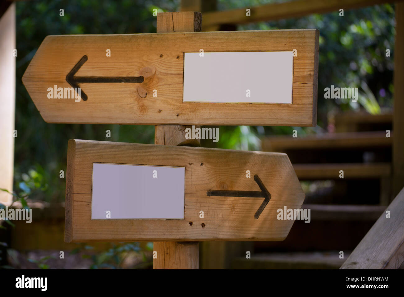 Wooden road sign with two opposite arrow directions with blank copy ...