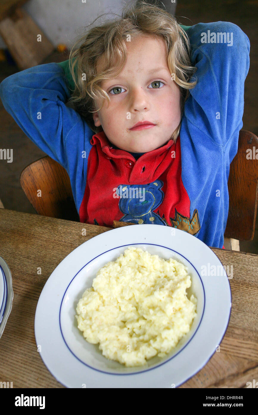 Child contemplating over the full plate toddler alone Stock Photo - Alamy