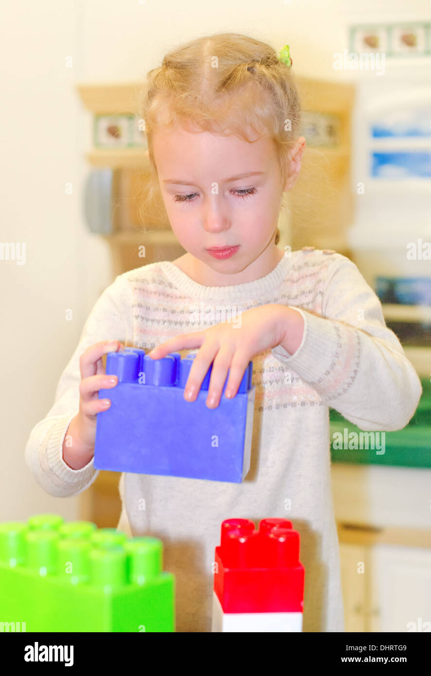 Little girl playing with building blocks Stock Photo - Alamy