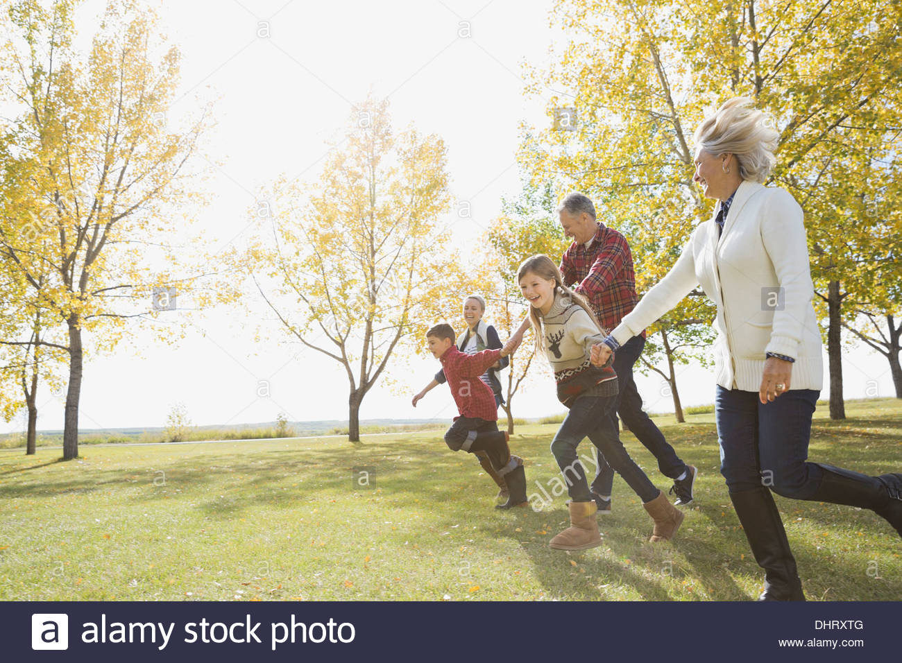 Multi-generation family running in park Stock Photo - Alamy