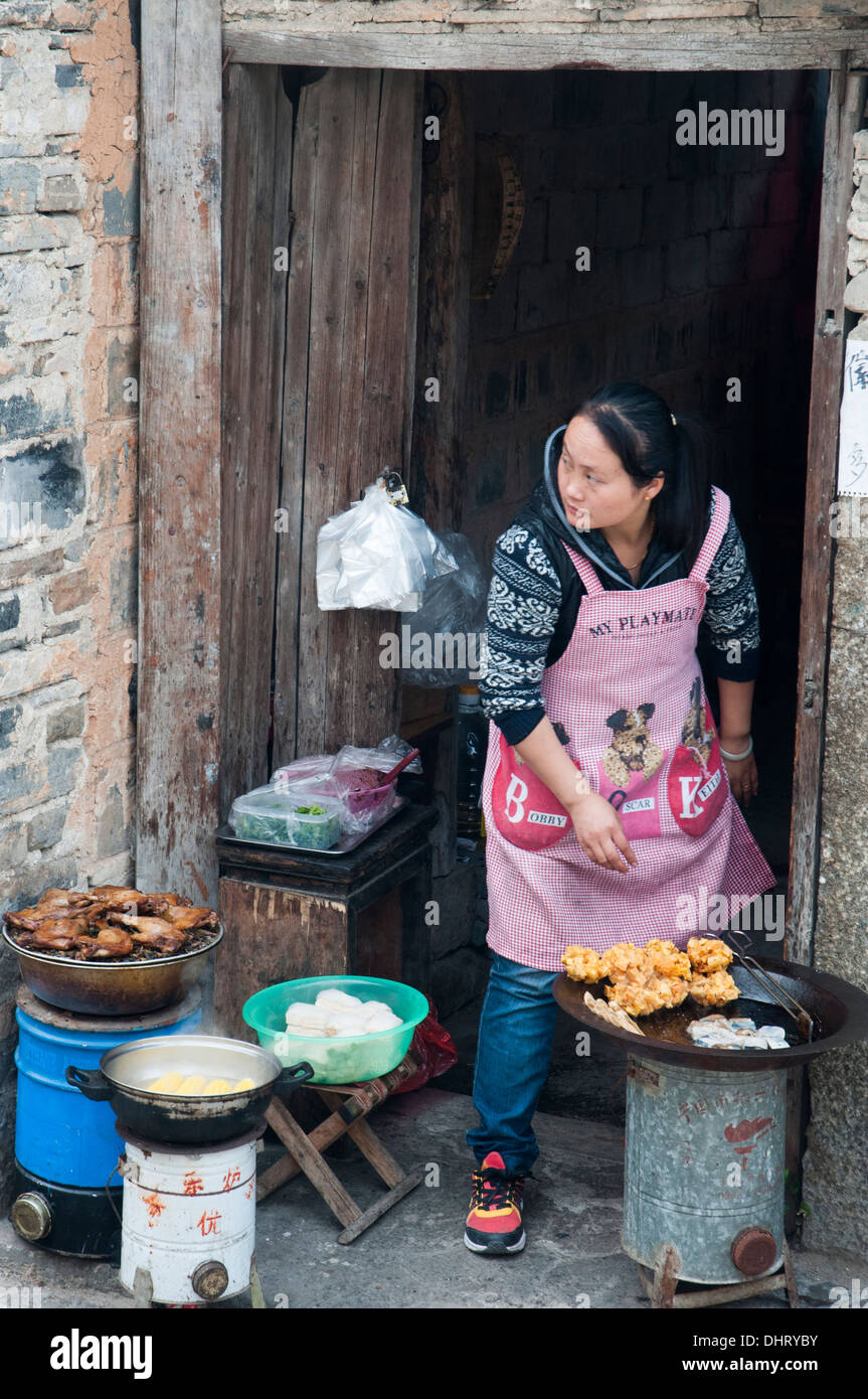 Woman cooking street food in Hongcun heritage village in Huizhou region ...