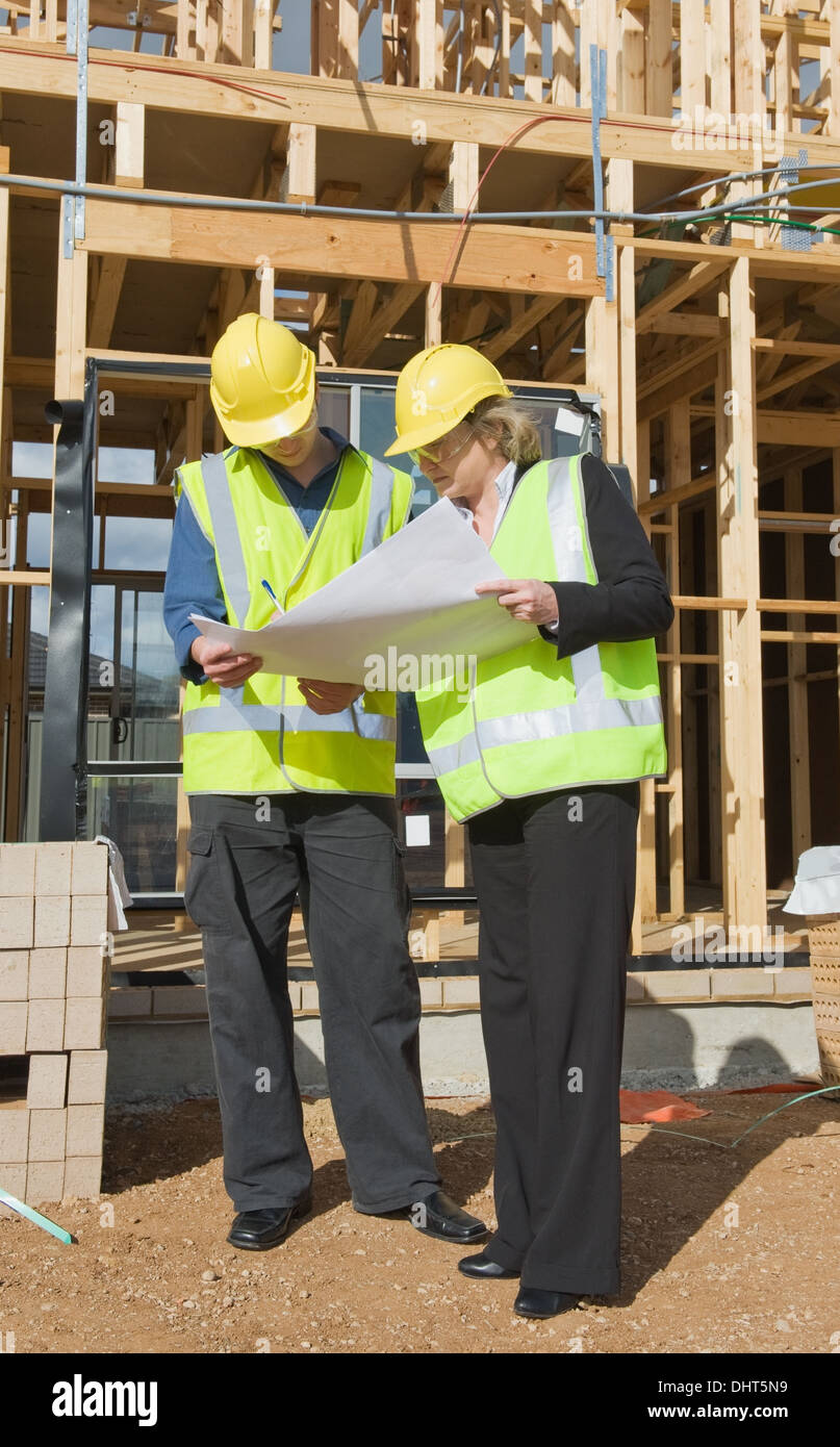 civil engineer and worker discussing issues at the construction site ...