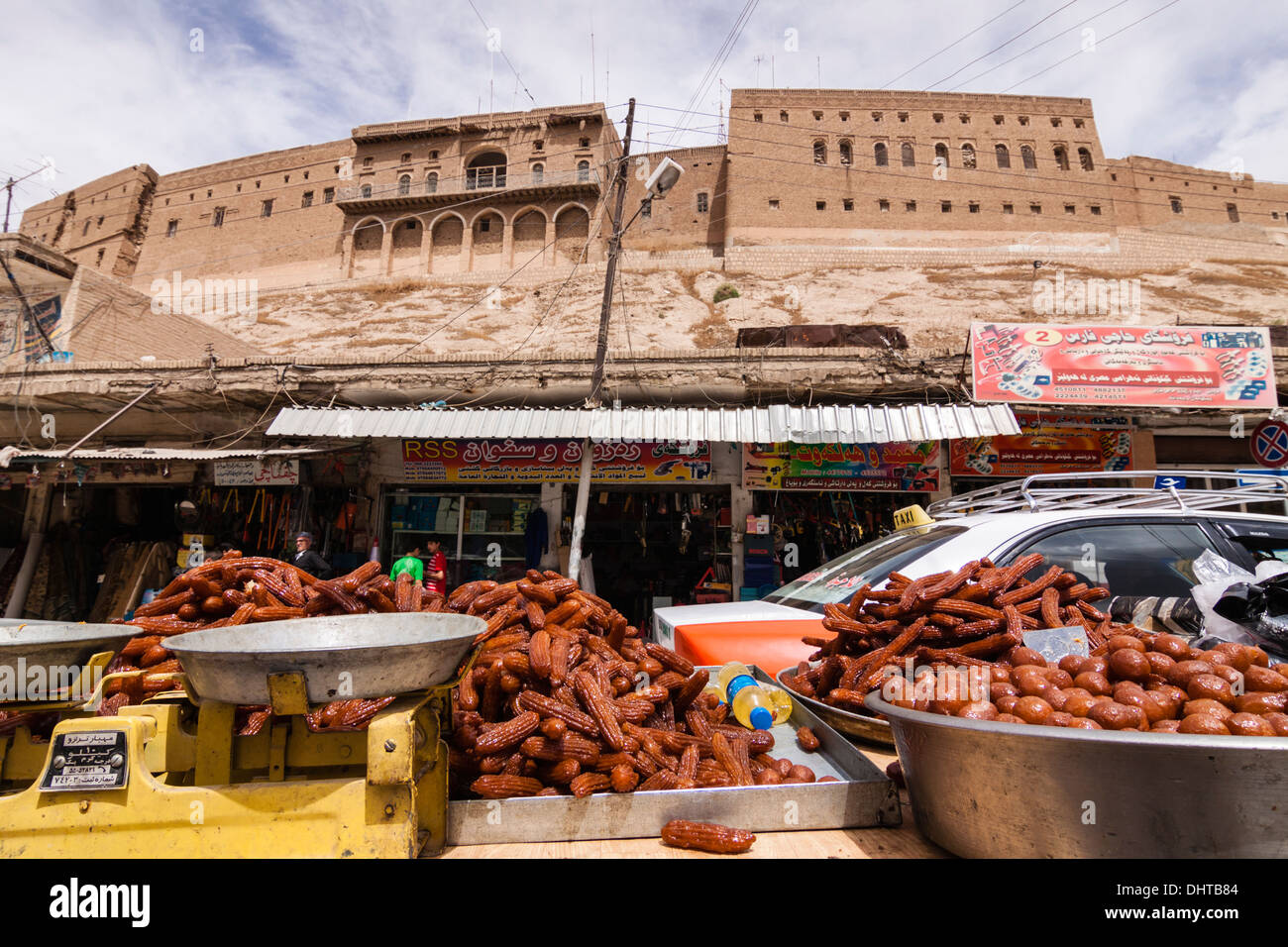 Sweets sold in a street market with citadel in background. Erbil, Iraq ...