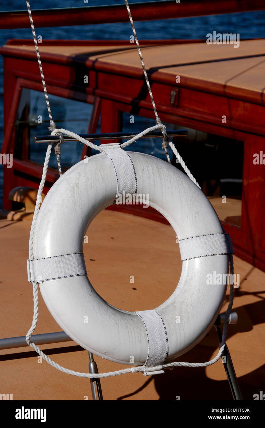 White life ring on vintage wooden sailboat. This device is made of ...