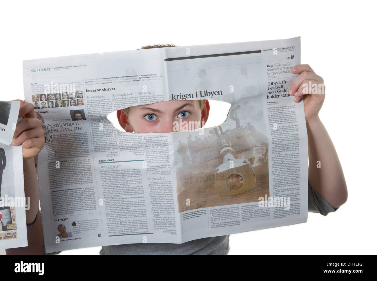 Boy reading newspaper with a hole as a spy Stock Photo - Alamy
