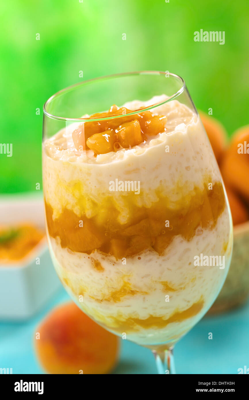 Fresh homemade rice pudding with peach compote served in a high glass ...