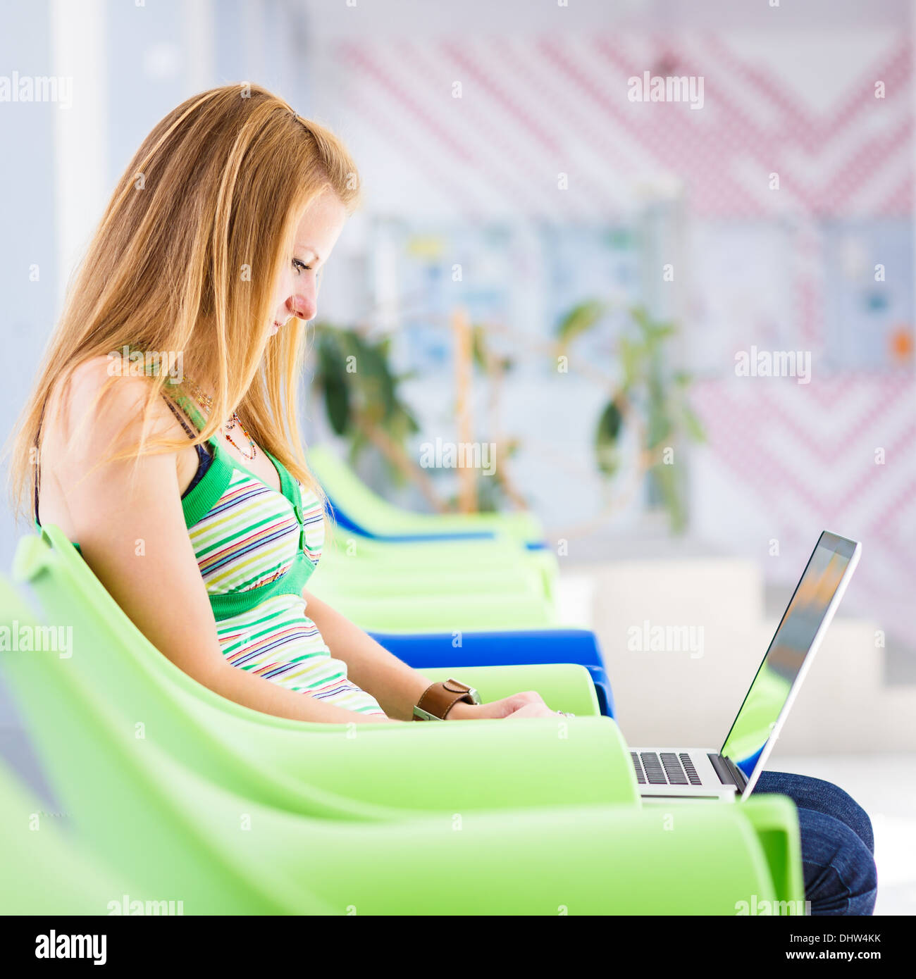 pretty female college student working on her laptop computer on campus ...