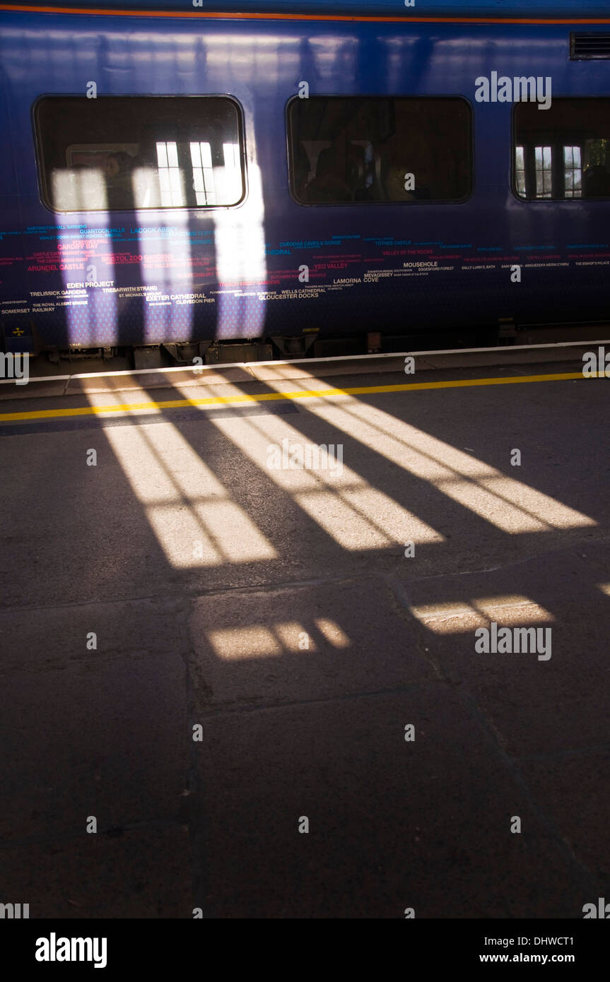 Sunlight creates a pattern of light on platform of railway station and ...