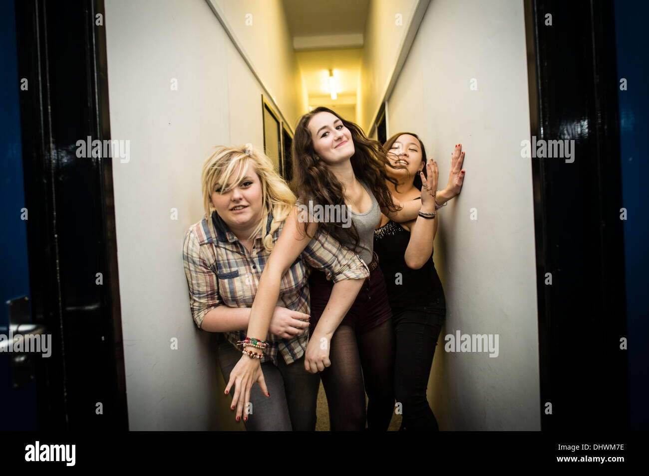 Three young women pushing and shoving each other out of the way in a ...