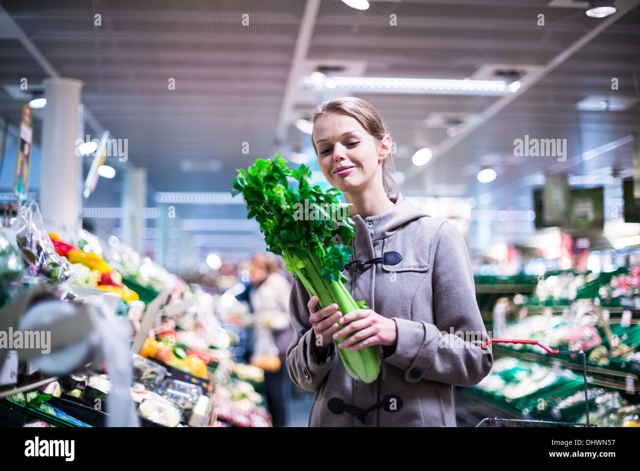Beautiful young woman shopping for fruits and vegetables in produce ...