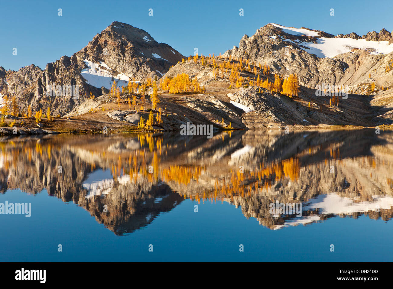 Fall larch and distant peaks reflected in Lower Ice Lake, Glacier Peak ...
