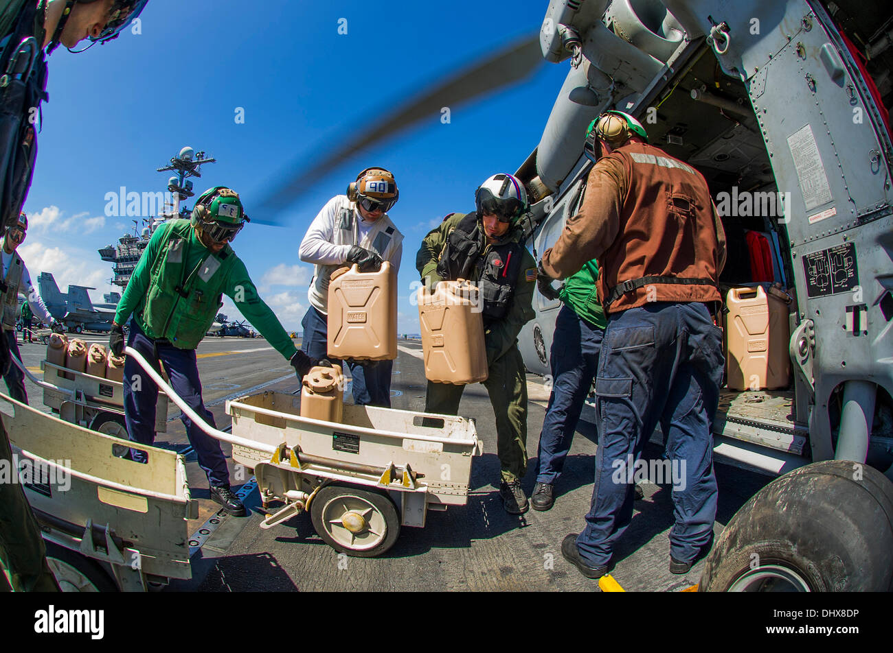Sailors aboard the USS George Washington load containers of fresh water ...