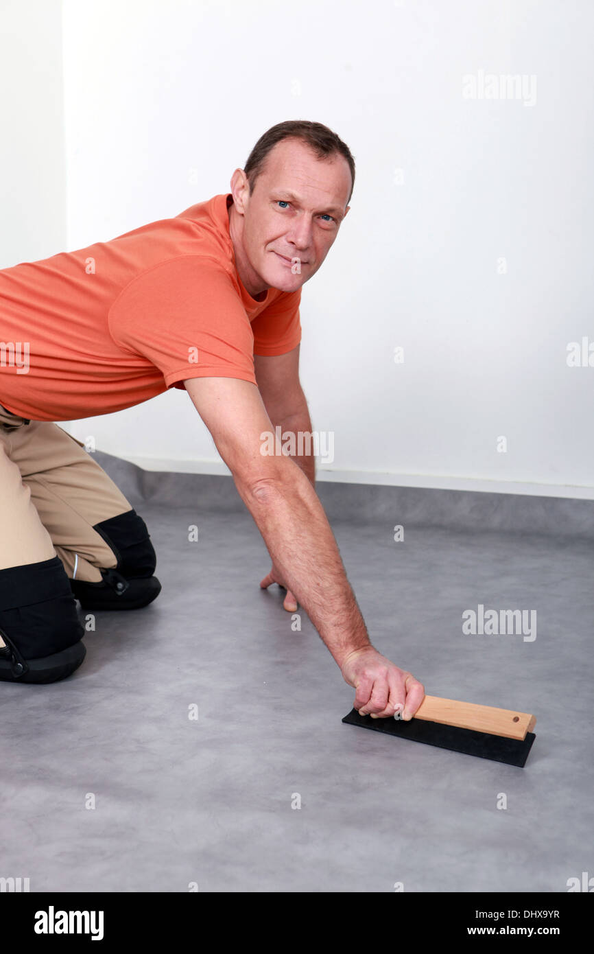 Man smoothing carpet Stock Photo - Alamy