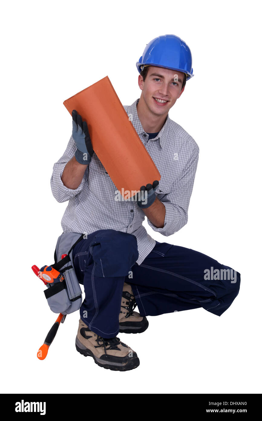 Craftsman crouching with tile Stock Photo - Alamy