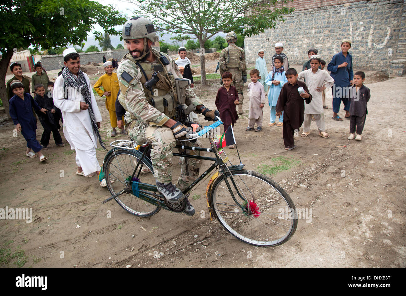 An Afghan special forces commando rides a bicycle while playing with ...