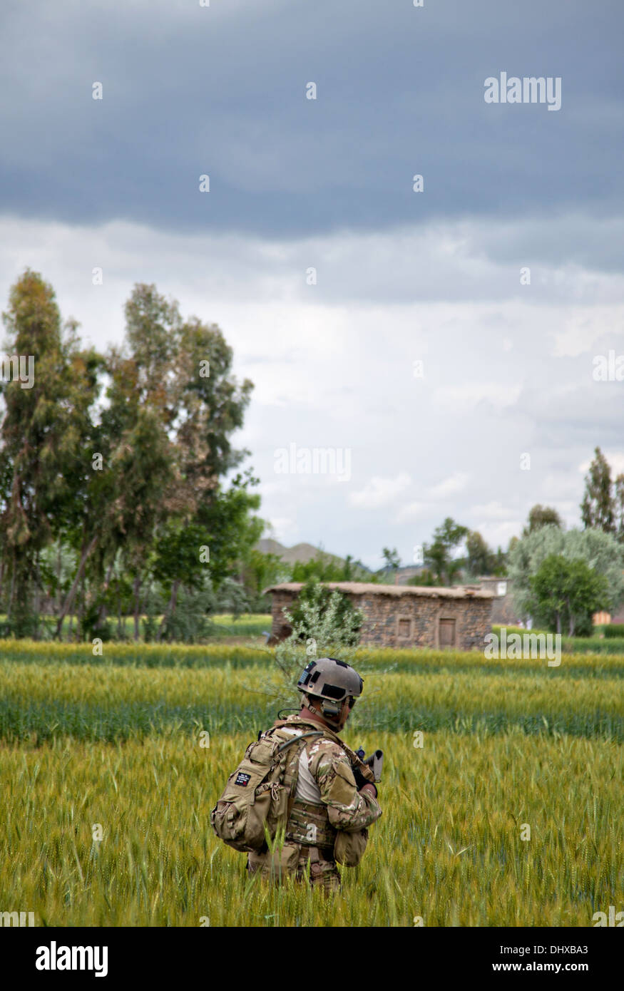 Afghan special forces commando patrols through a field during a mission ...
