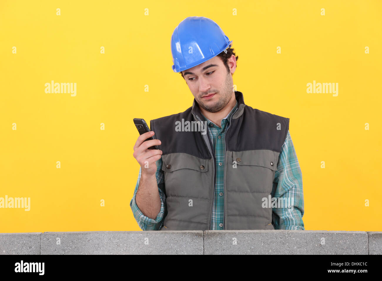 Worker behind wall Stock Photo - Alamy