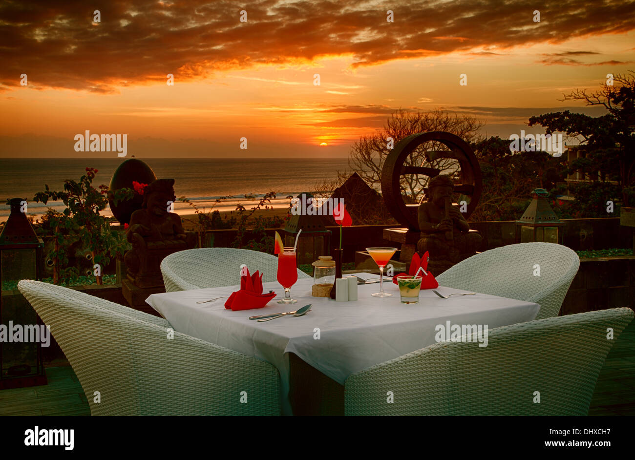 Romantic dinner table for two setup on balcony against dramatic sunset ...