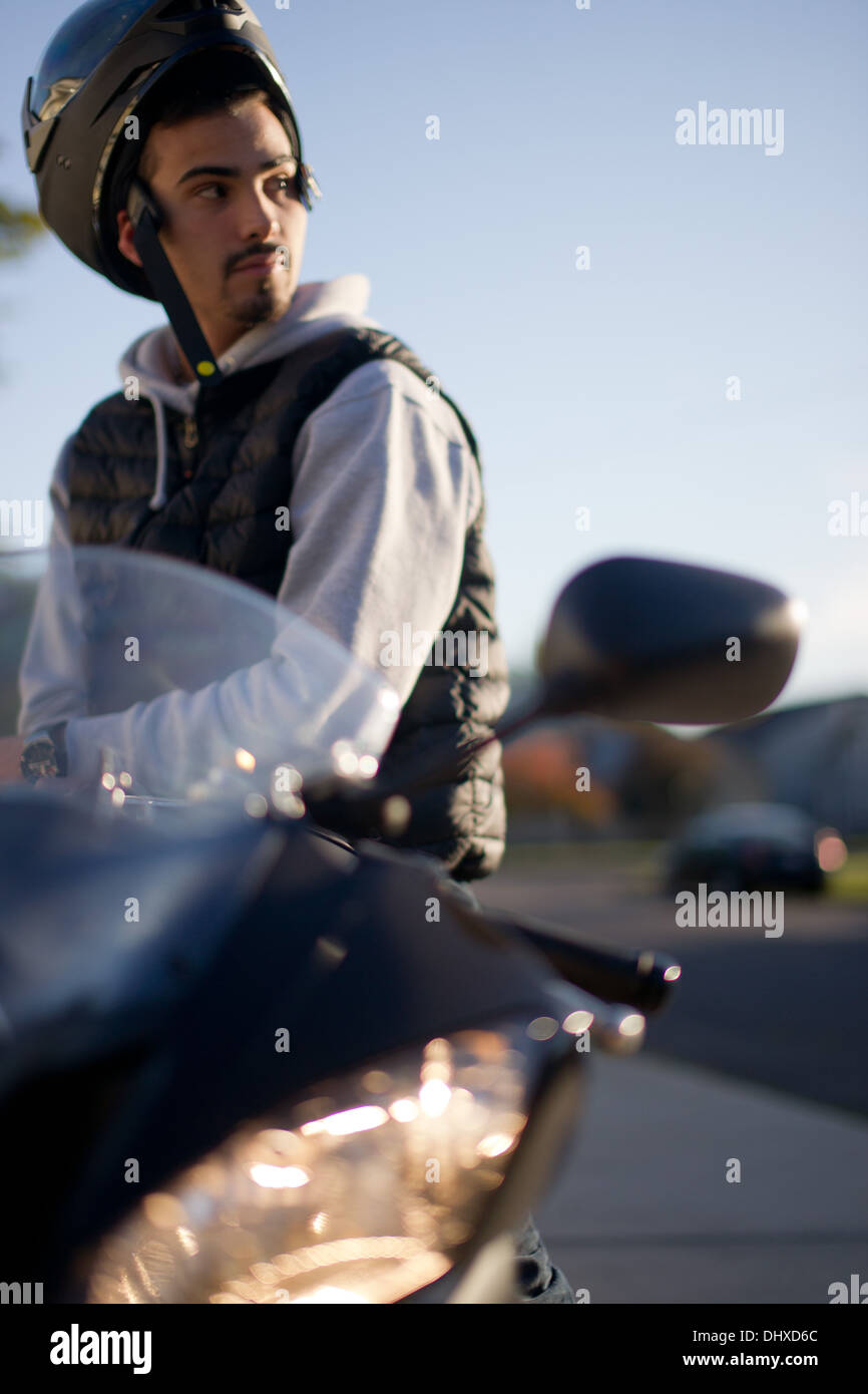 Young Man Sitting on Motorcycle with Raised Helmet on Head Stock Photo ...