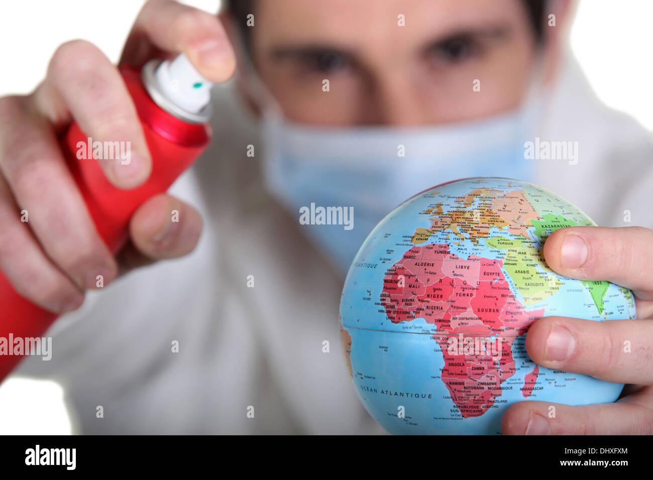 Man spraying an aerosol over planet earth Stock Photo - Alamy