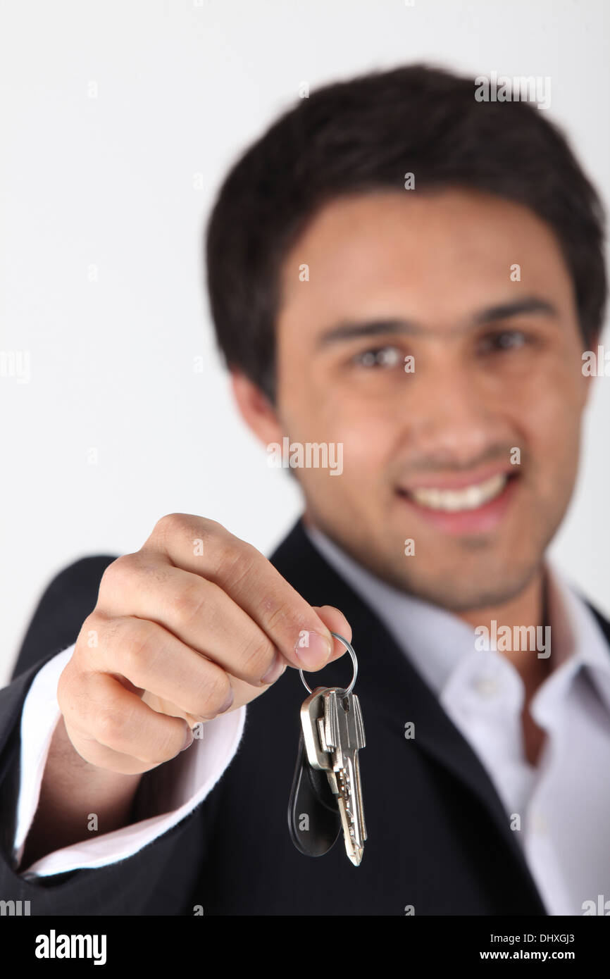 Confident estate-agent handing keys over Stock Photo - Alamy