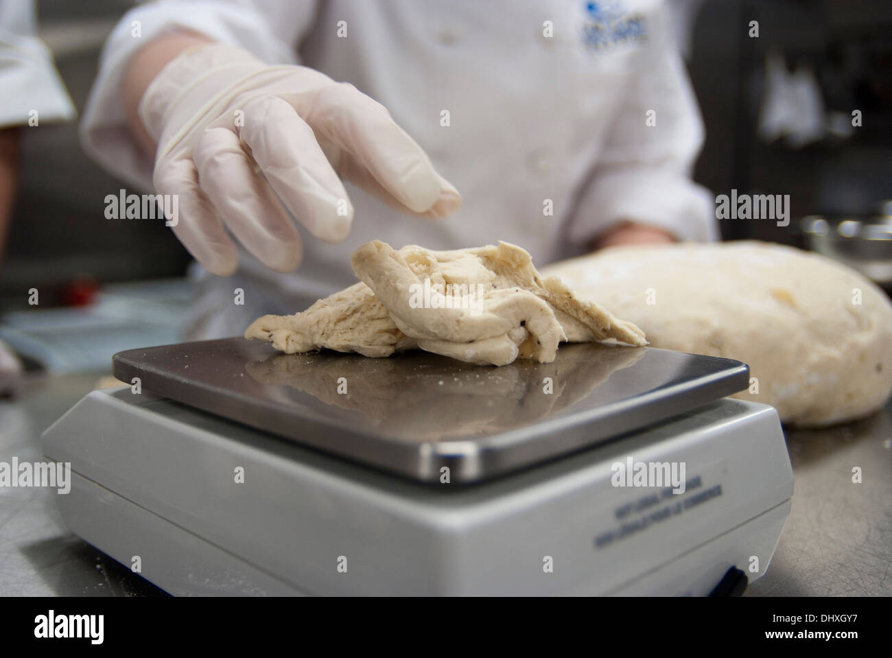 Trainee chef measuring dough in a commercial kitchen Stock Photo - Alamy