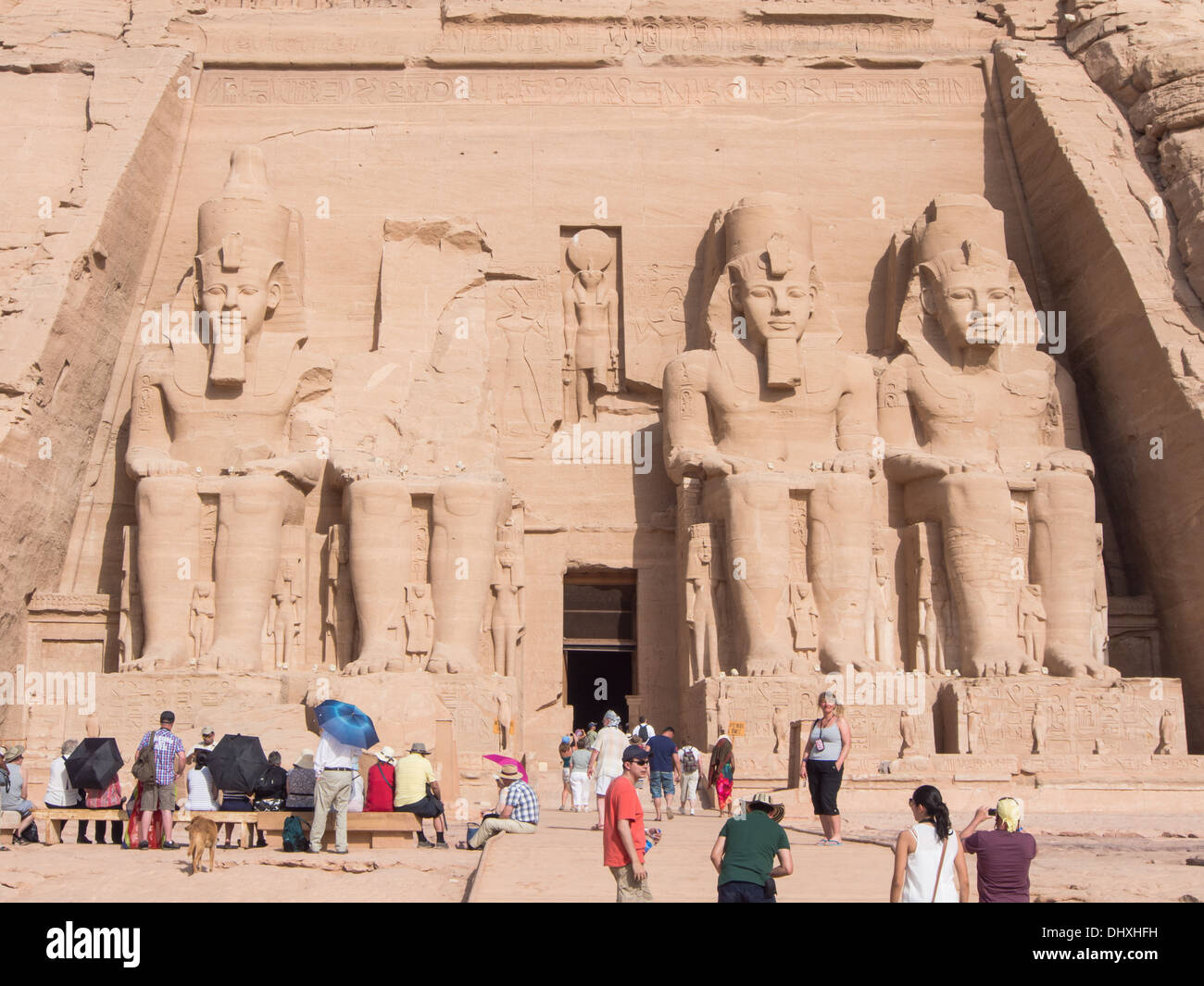 Tourists look at the four statues of Ramses II and the entrance to the ...