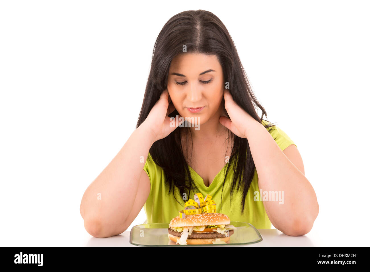 Beautiful large woman, trying to resist to an appetizing hamburger ...