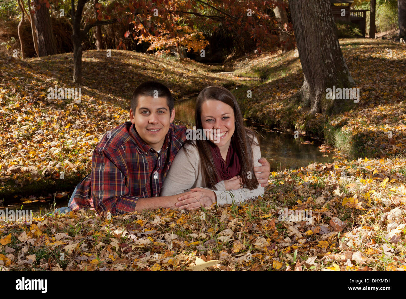Loving couple posing together during the fall / autumn, with natural ...