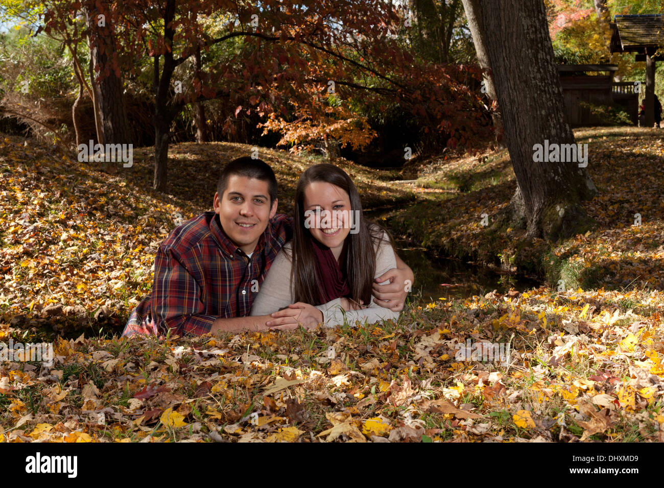Loving couple posing together during the fall / autumn, with natural ...